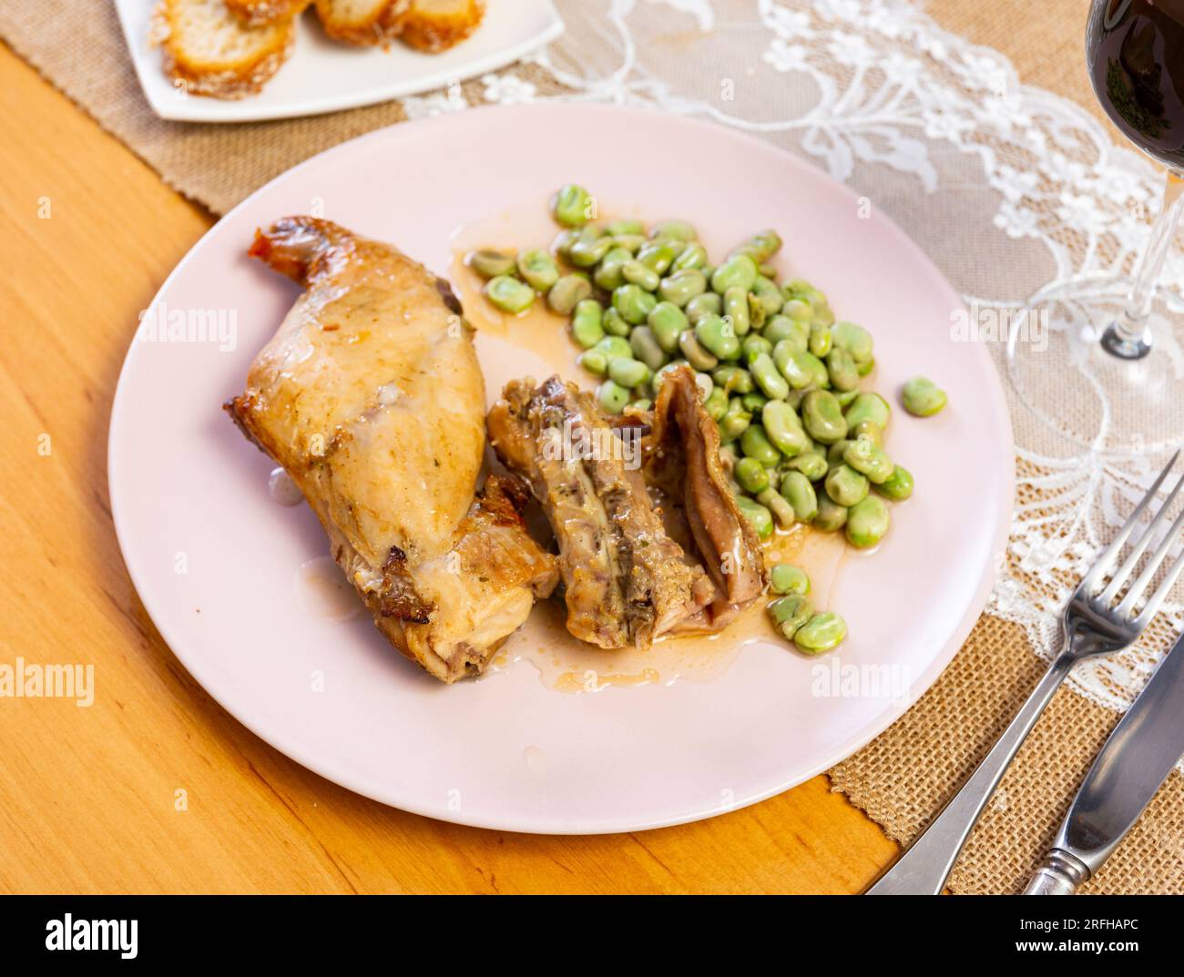 Fried rabbit on a plate with beans and parsley Stock Photo - Alamy