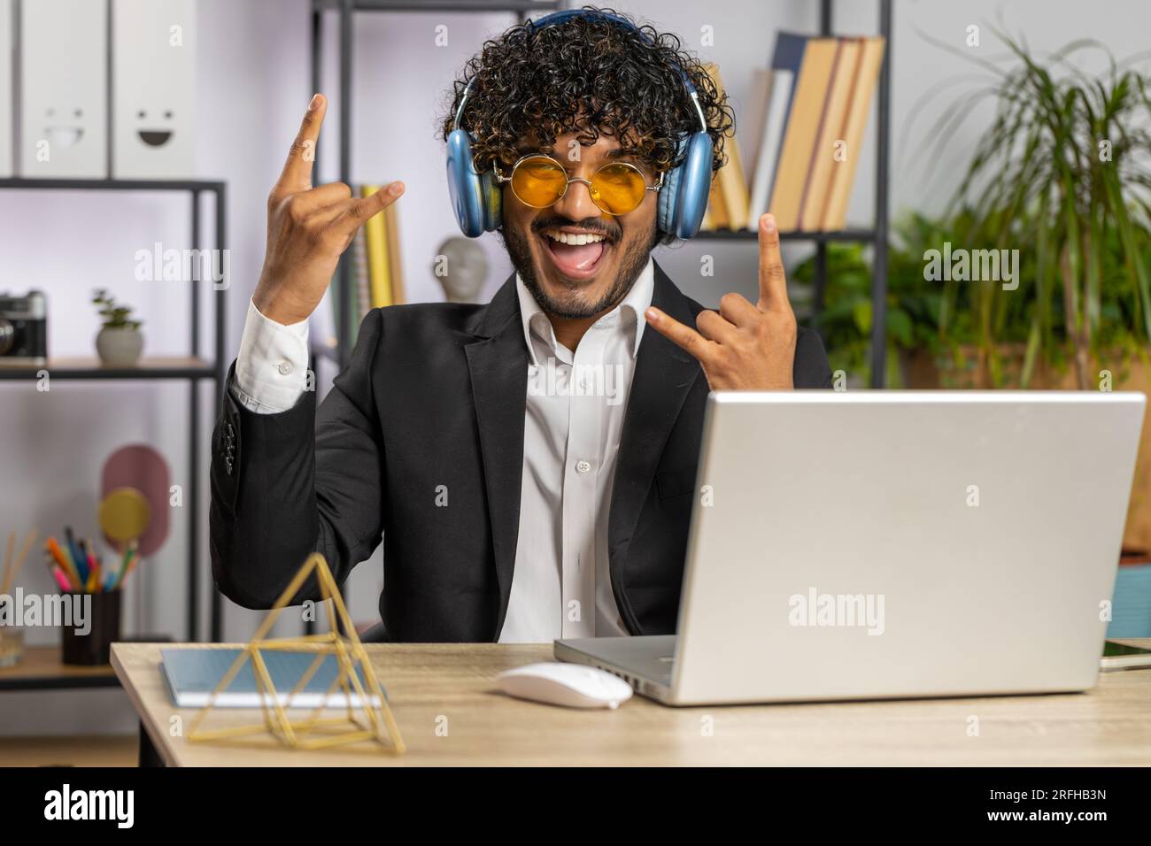 Happy relaxed overjoyed indian businessman working on laptop computer ...