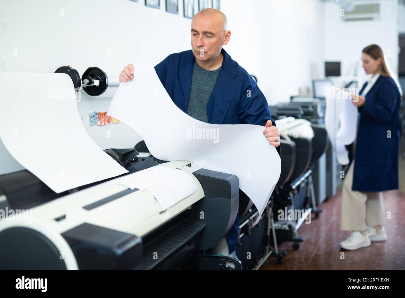 Man working in printing office, using printer Stock Photo - Alamy