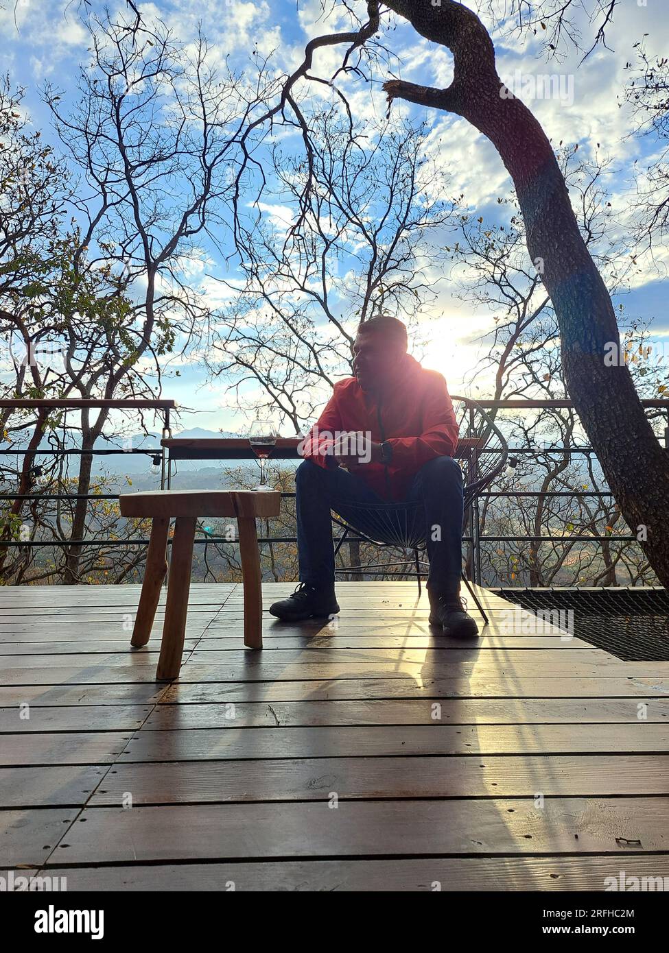 Dark-haired 40-year-old Latino man drinks a glass of wine on the ...