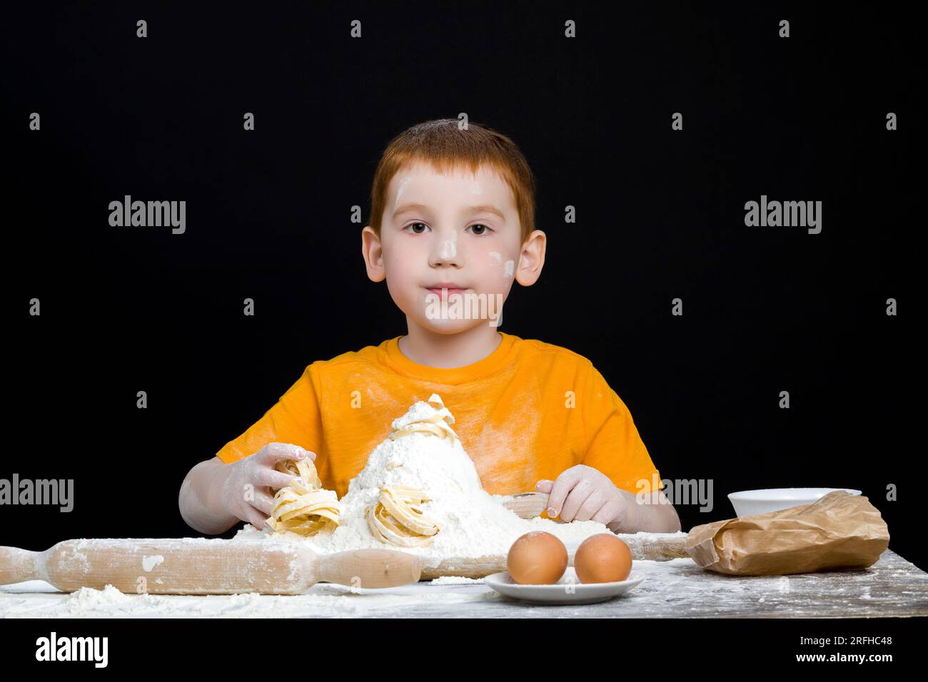 portrait of a baby boy in the kitchen while helping with cooking, a boy ...