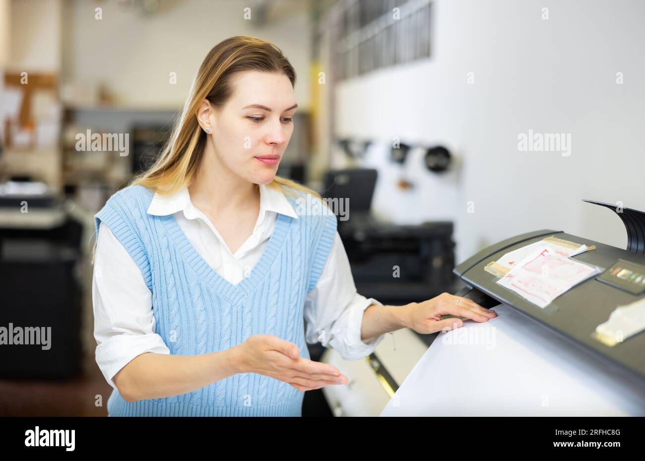 Woman employee of printing house works on modern printer Stock Photo ...