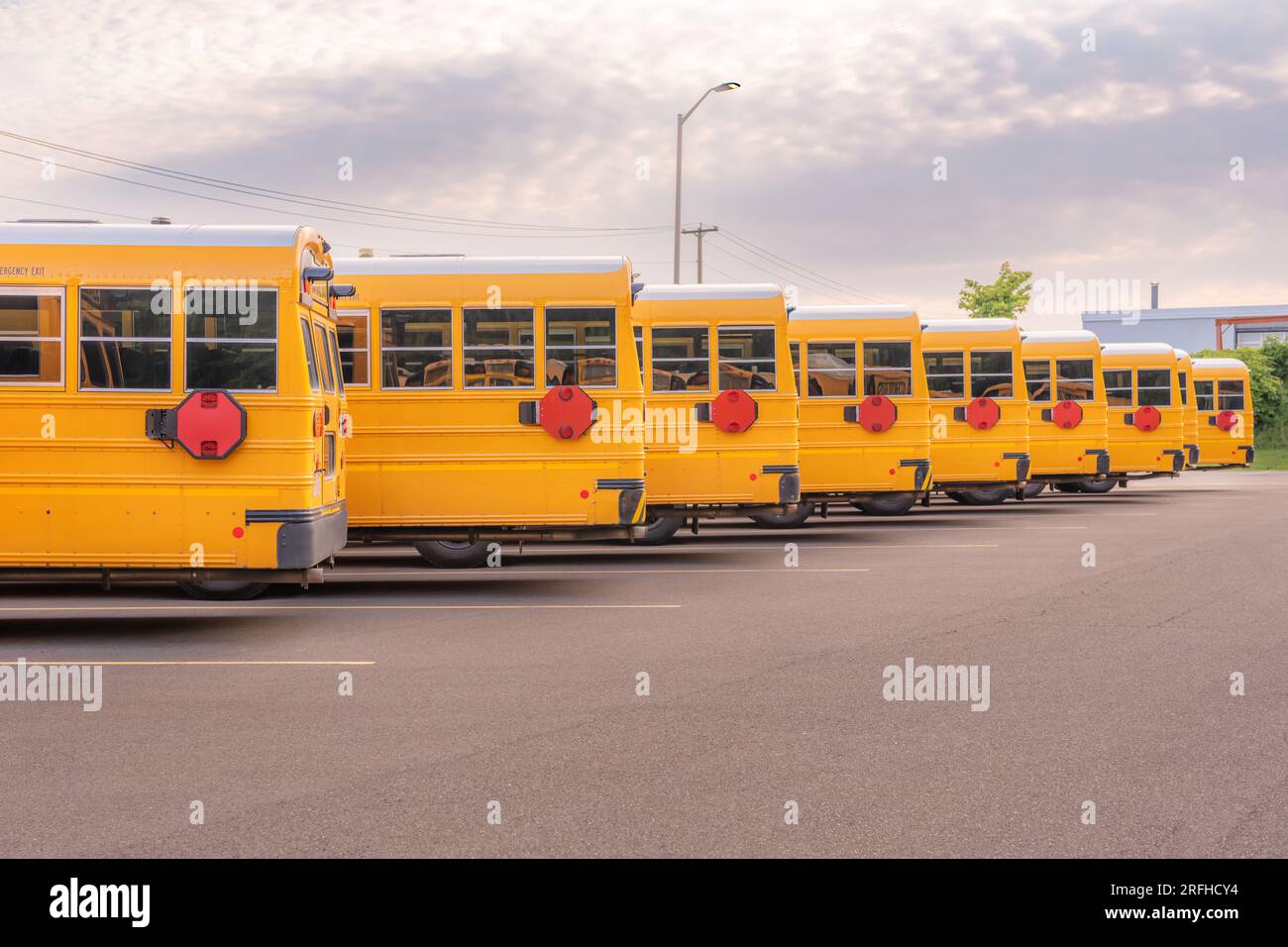 Yellow electric school bus plugged in at a charging station Stock Photo ...