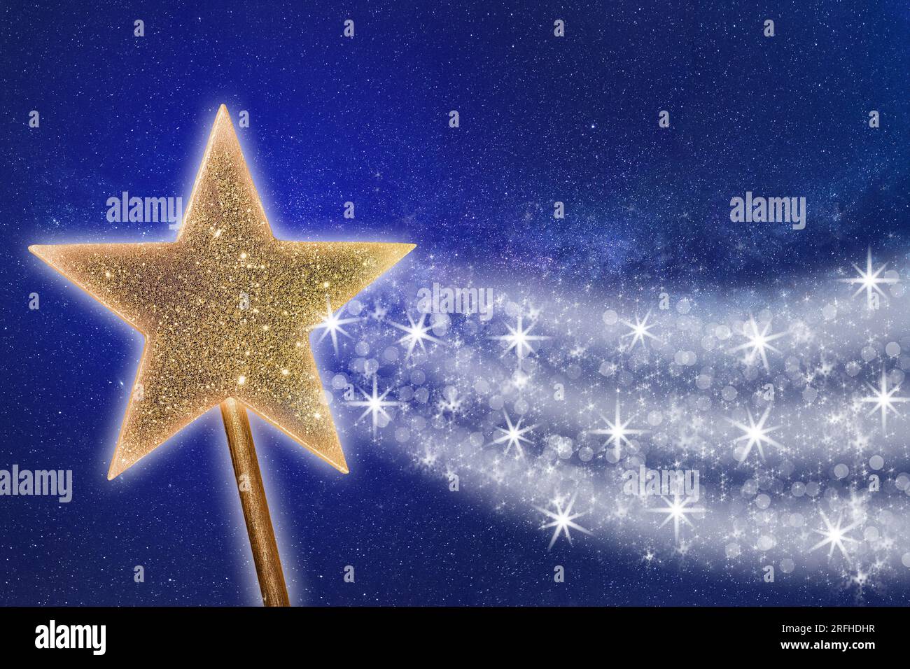 A magic wand in a dark blue star-filled sky creates a white stream of ...