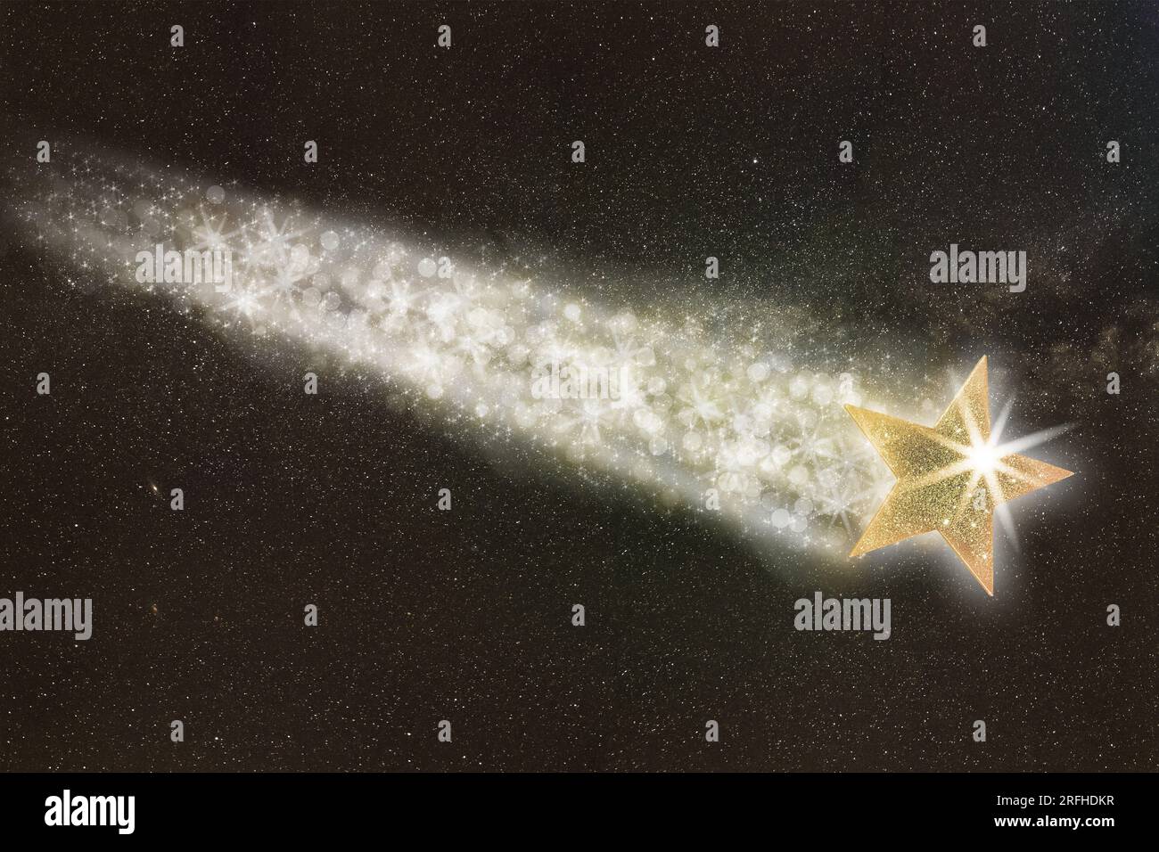 A falling star leaving a trail of star dust in a shimmering sky filled ...