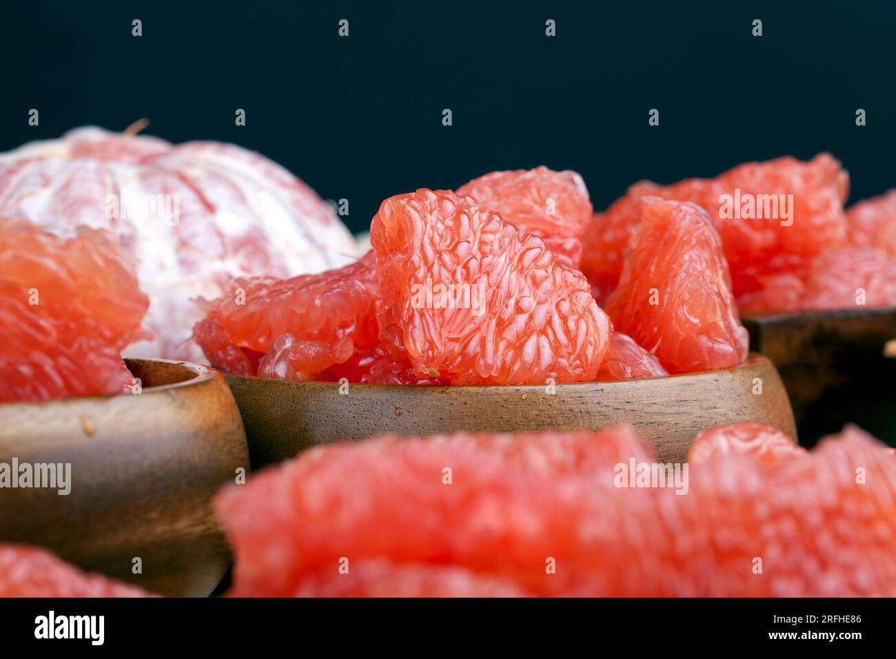 peeled pink grapefruit split into pieces while cooking, ready to eat ...