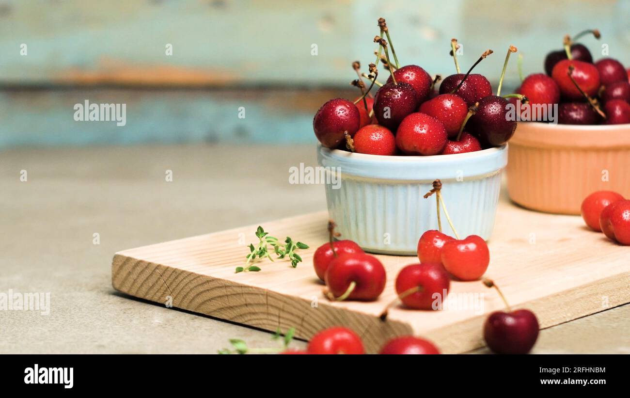 Red ripe cherries in ceramic bowls on kitchen countertop. Slide from ...