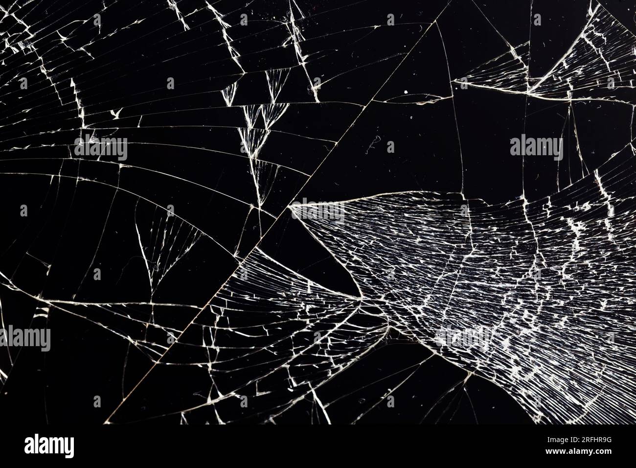 broken dirty glass with lots of damage and cracks on a black background ...