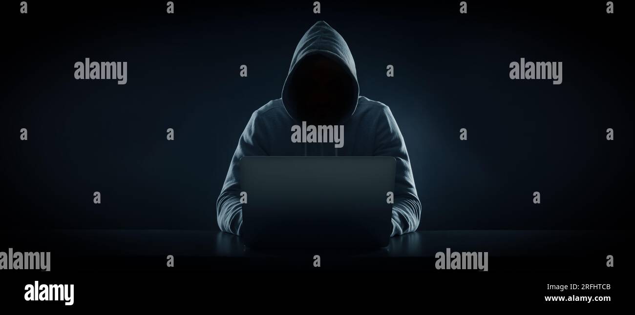 Anonymous man in hood using laptop on black background. Banner design ...