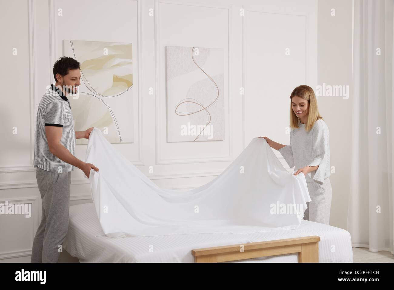 Couple changing bed linens at home. Domestic chores Stock Photo - Alamy