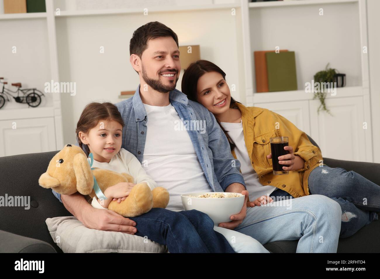 Happy family watching TV on sofa at home Stock Photo - Alamy