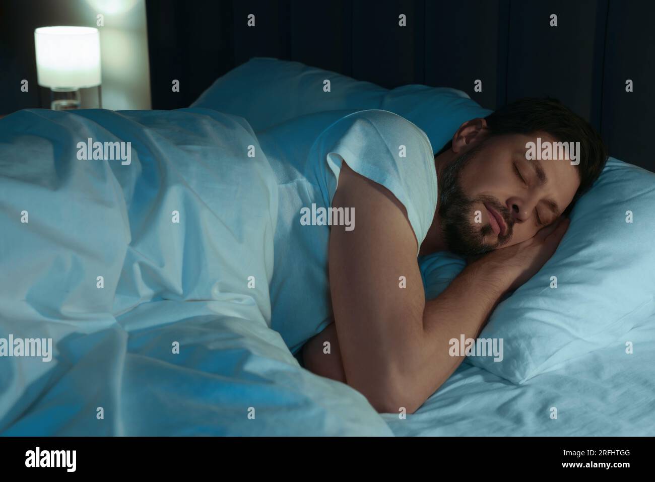 Handsome man sleeping in bed at night Stock Photo - Alamy