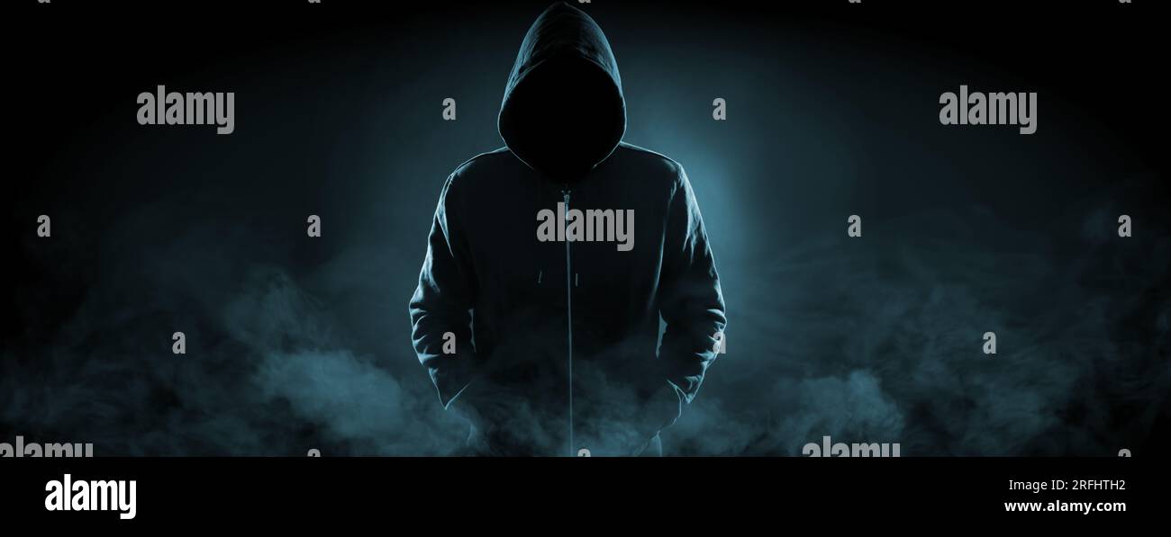 Anonymous man in hood surrounded by smoke on black background. Banner ...