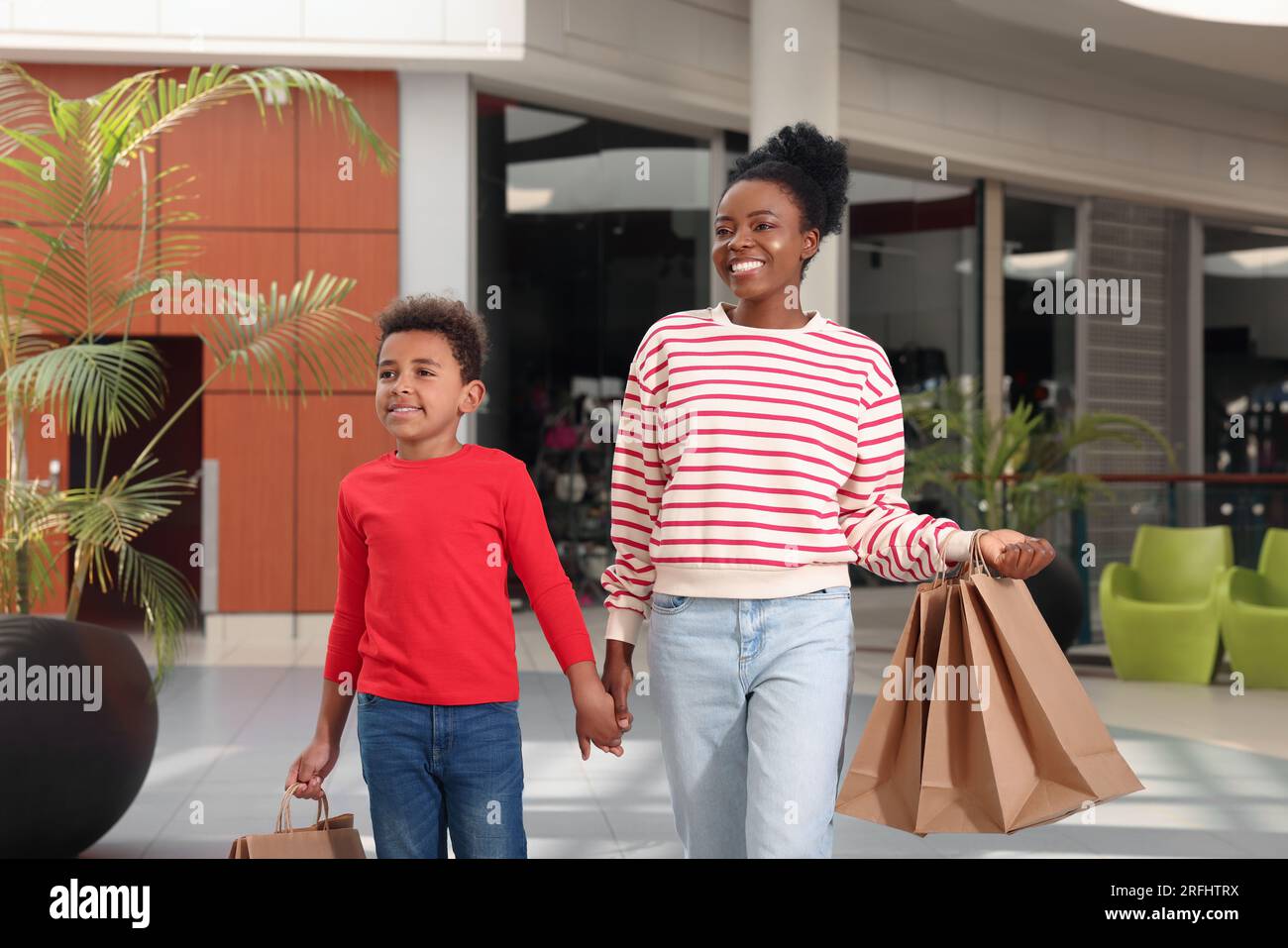 Family shopping. Happy mother and son with purchases in mall Stock ...