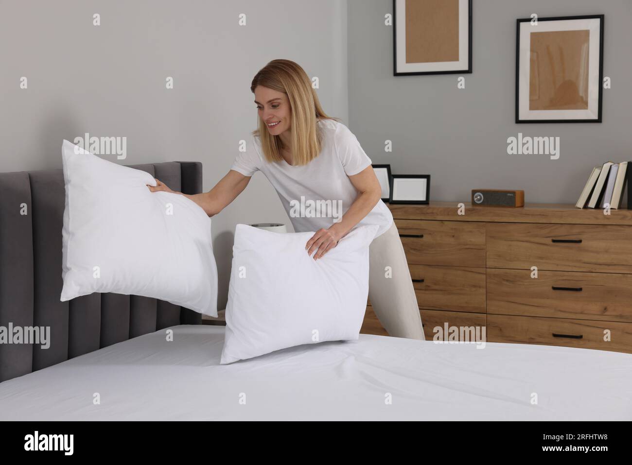 Woman arranging pillows on hi-res stock photography and images - Alamy