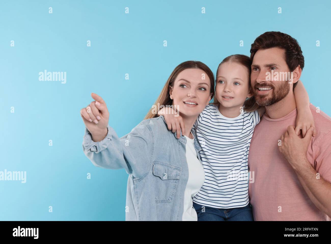 Happy family on light blue background, space for text Stock Photo - Alamy