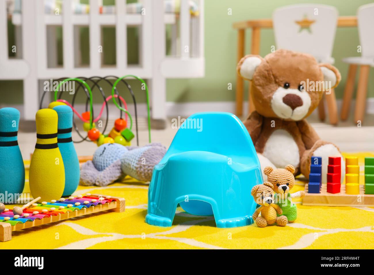 Light blue baby potty, teddy bear and many other toys in room. Toilet ...