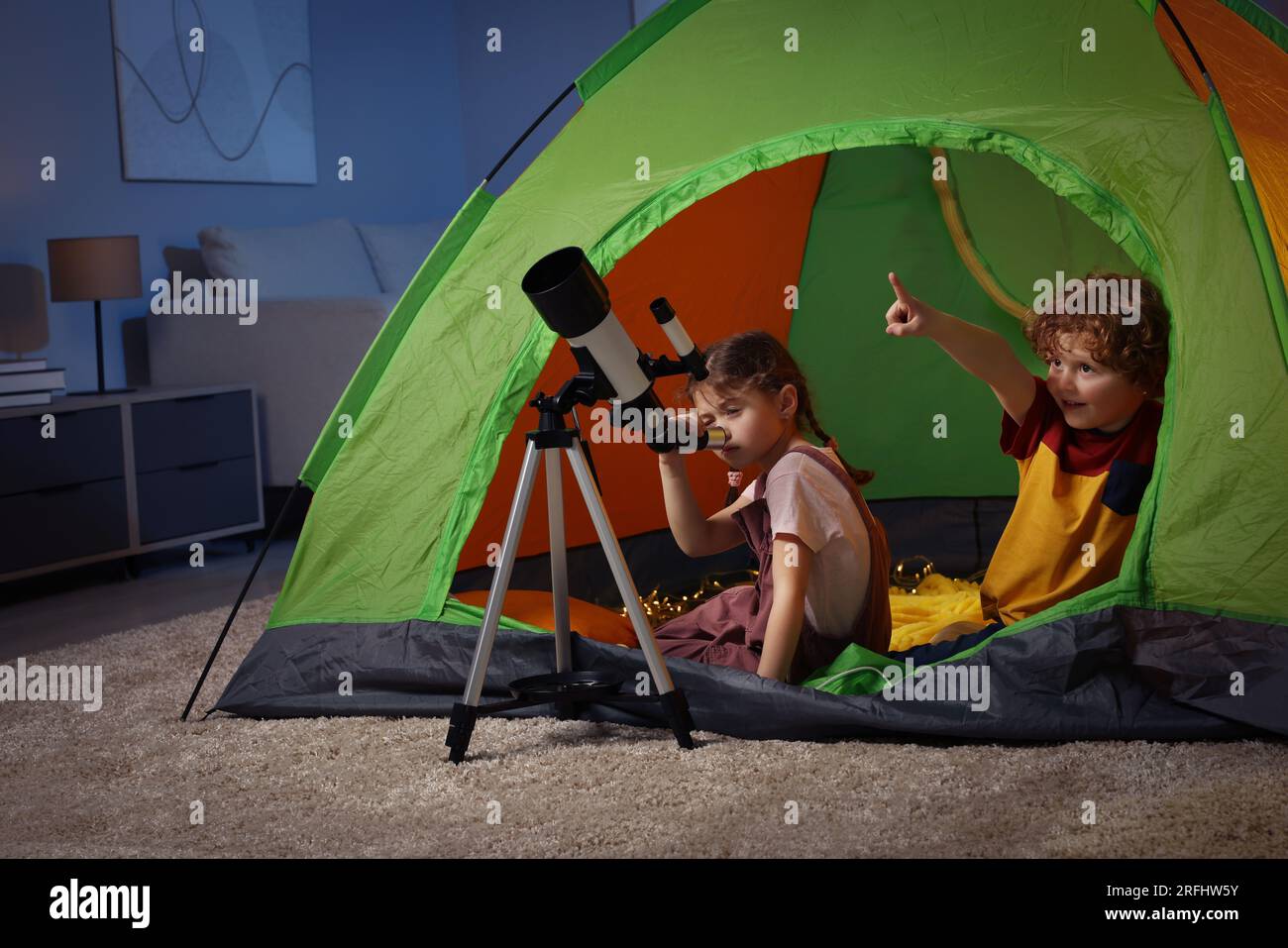Cute little children looking at stars through telescope while sitting ...