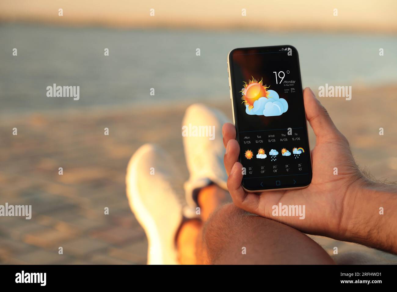 Man checking weather using app on smartphone near river, closeup. Data ...