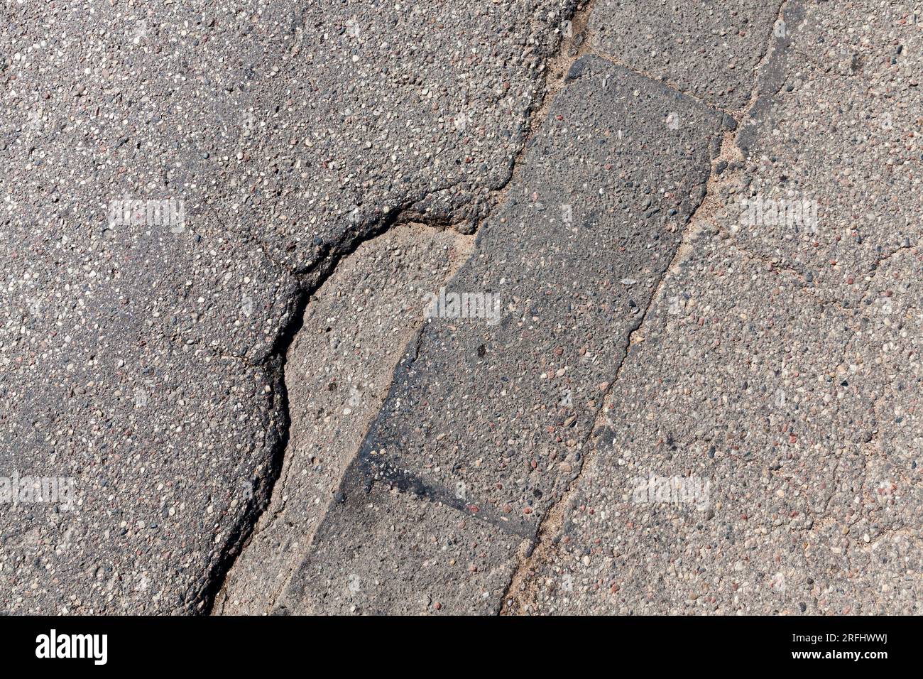 an asphalt road with a lot of holes and damage, a poorly made ...