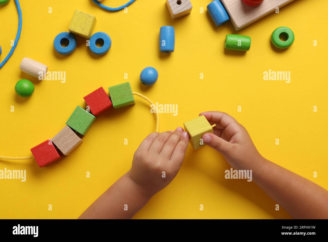 Motor skills development. Little child playing with wooden pieces and ...