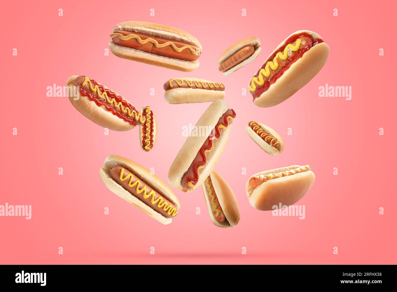 Many tasty hot dogs falling on pink background Stock Photo - Alamy