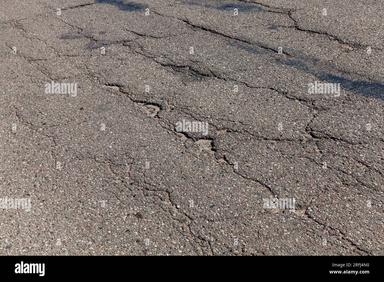 an asphalt road with a lot of holes and damage, a poorly made ...