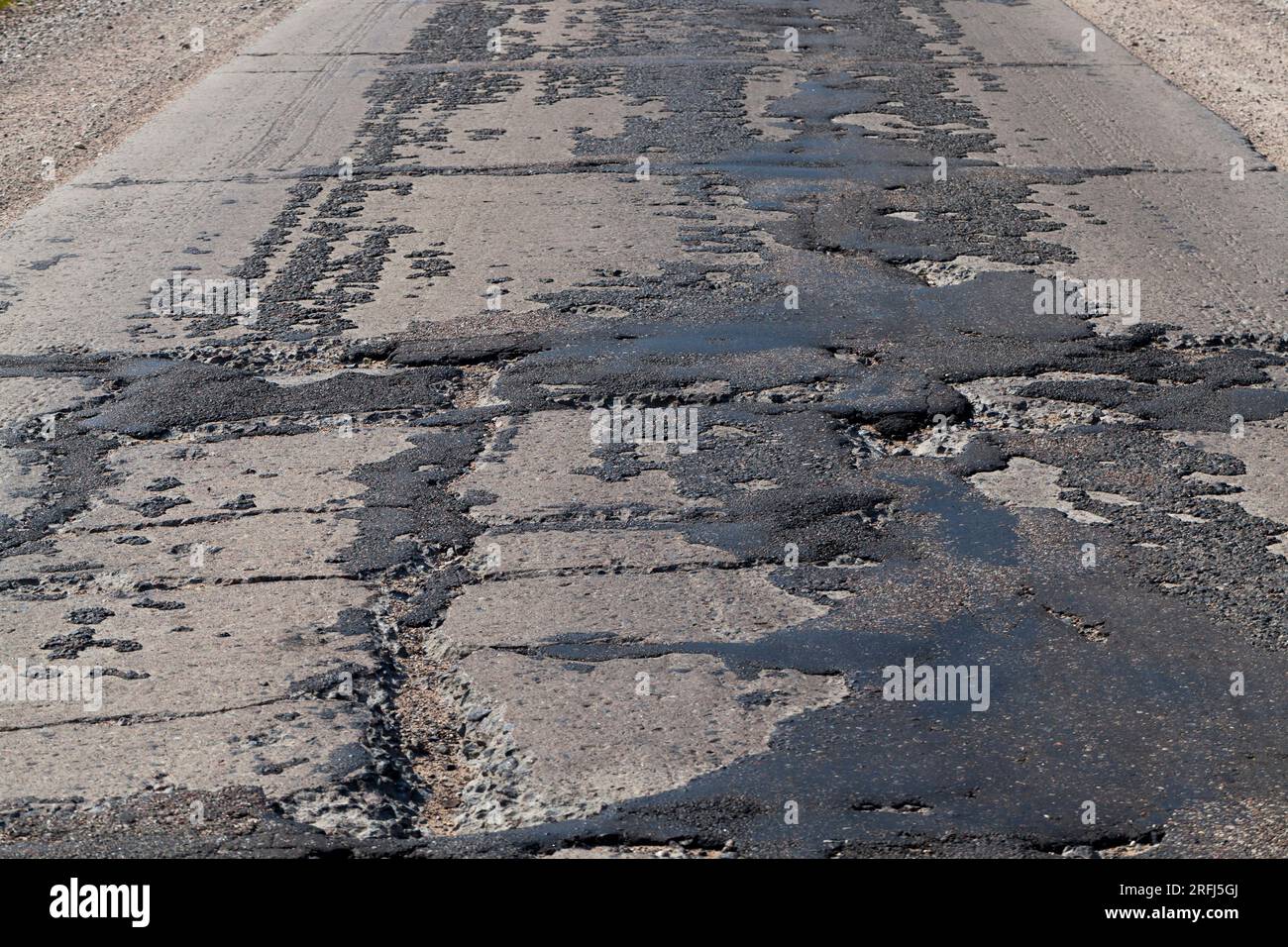 a bad road with poorly repaired potholes and pits, a road of poor ...