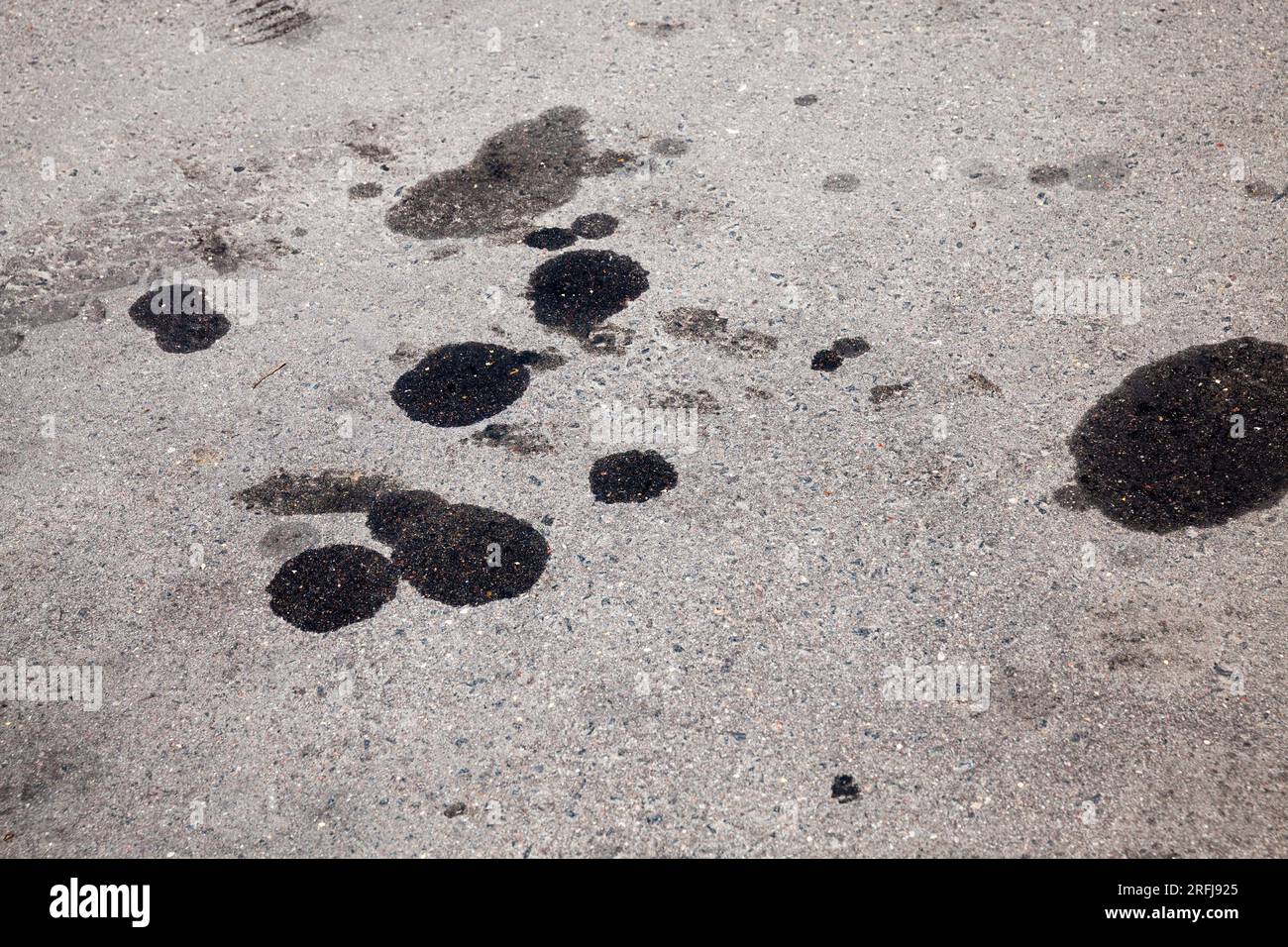 car oil stains on an asphalt road, stains from engine oil flowing out ...
