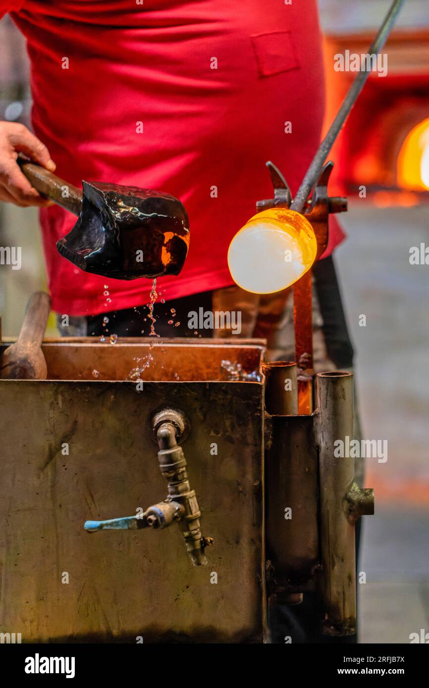 Glassblower shaping a glass, blowpipe Stock Photo - Alamy