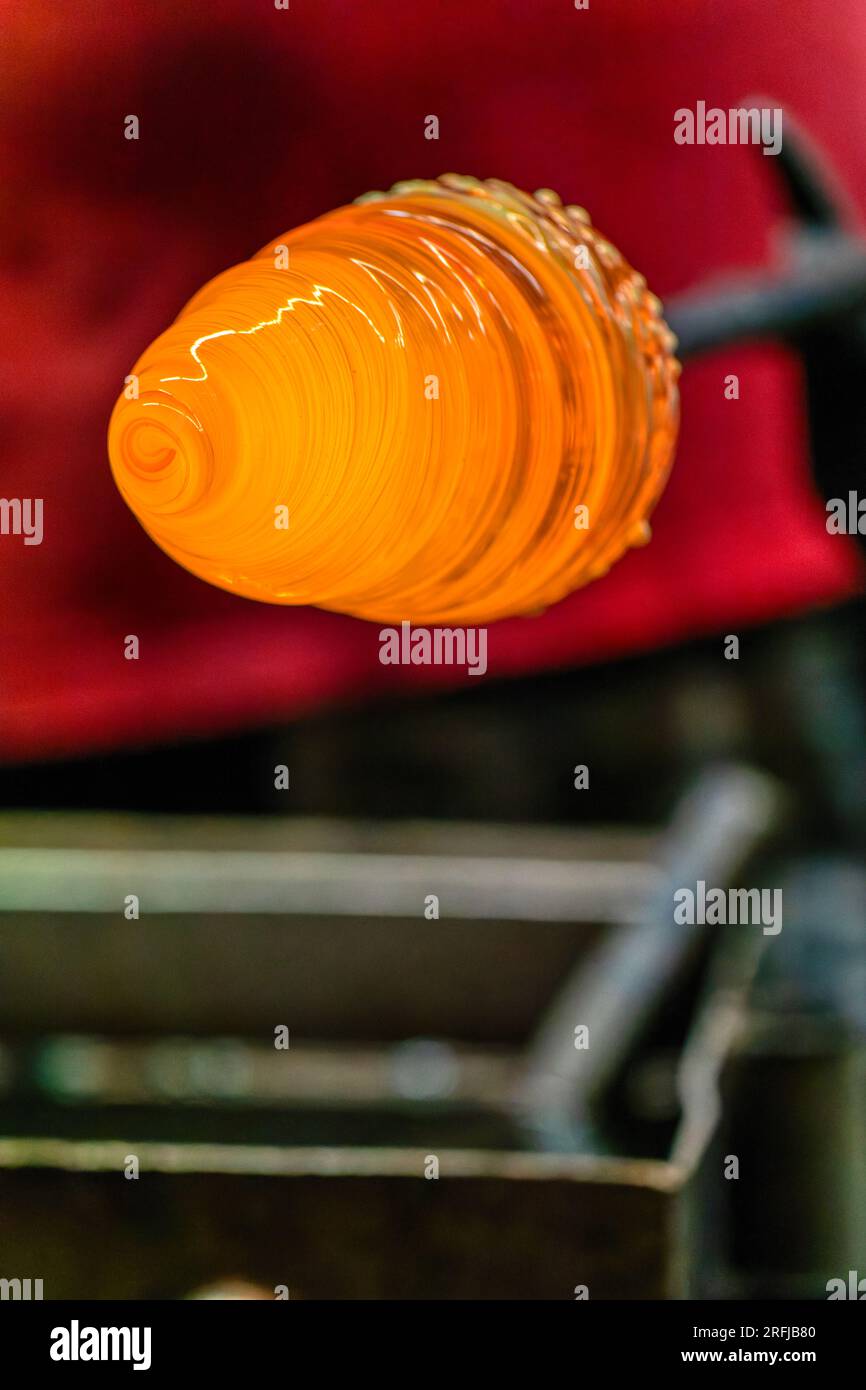 Glassblower shaping a glass, blowpipe Stock Photo - Alamy