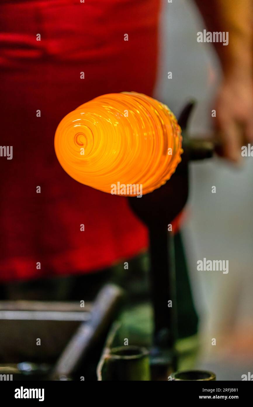 Glassblower shaping a glass, blowpipe Stock Photo - Alamy