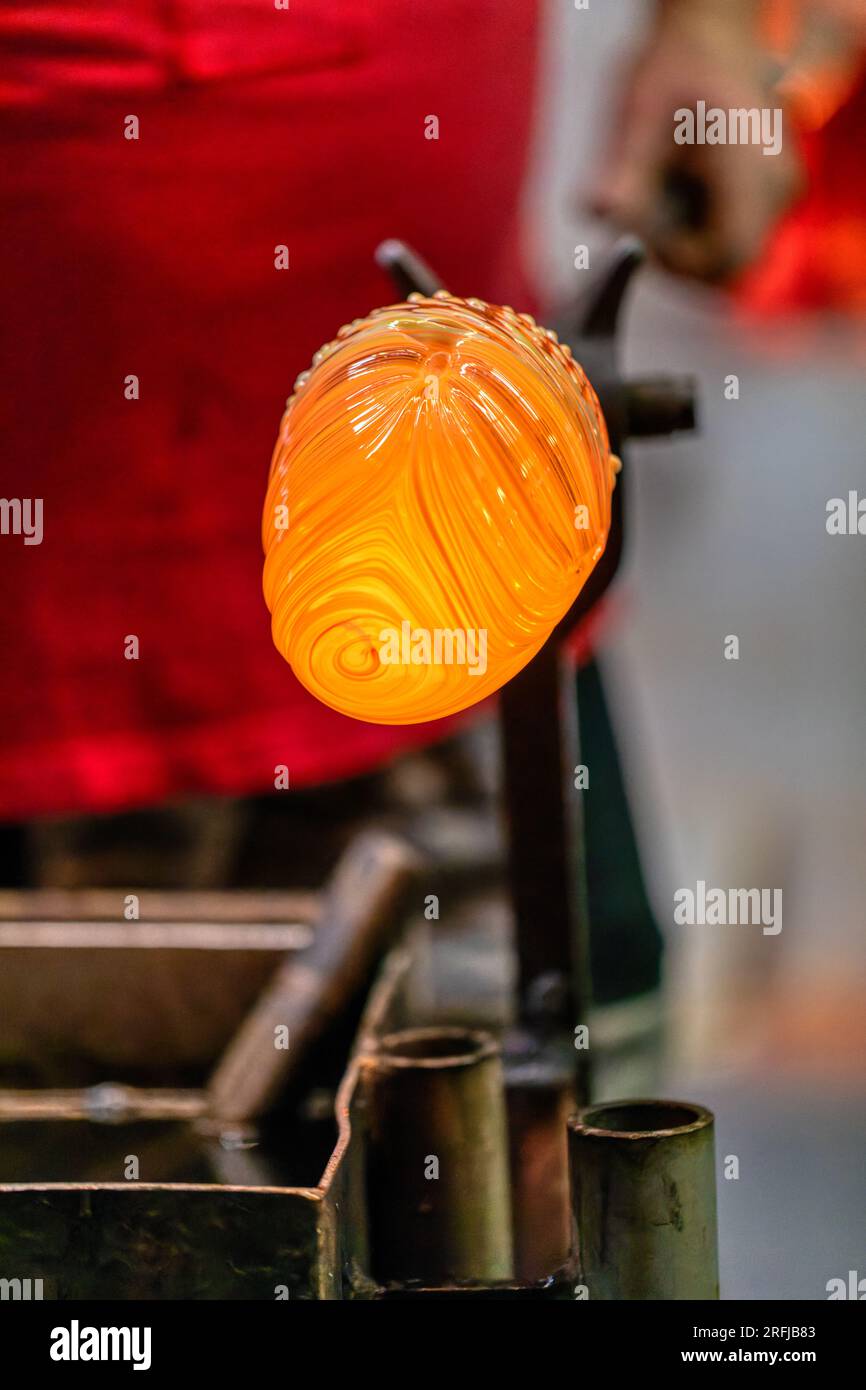 Glassblower shaping a glass, blowpipe Stock Photo - Alamy