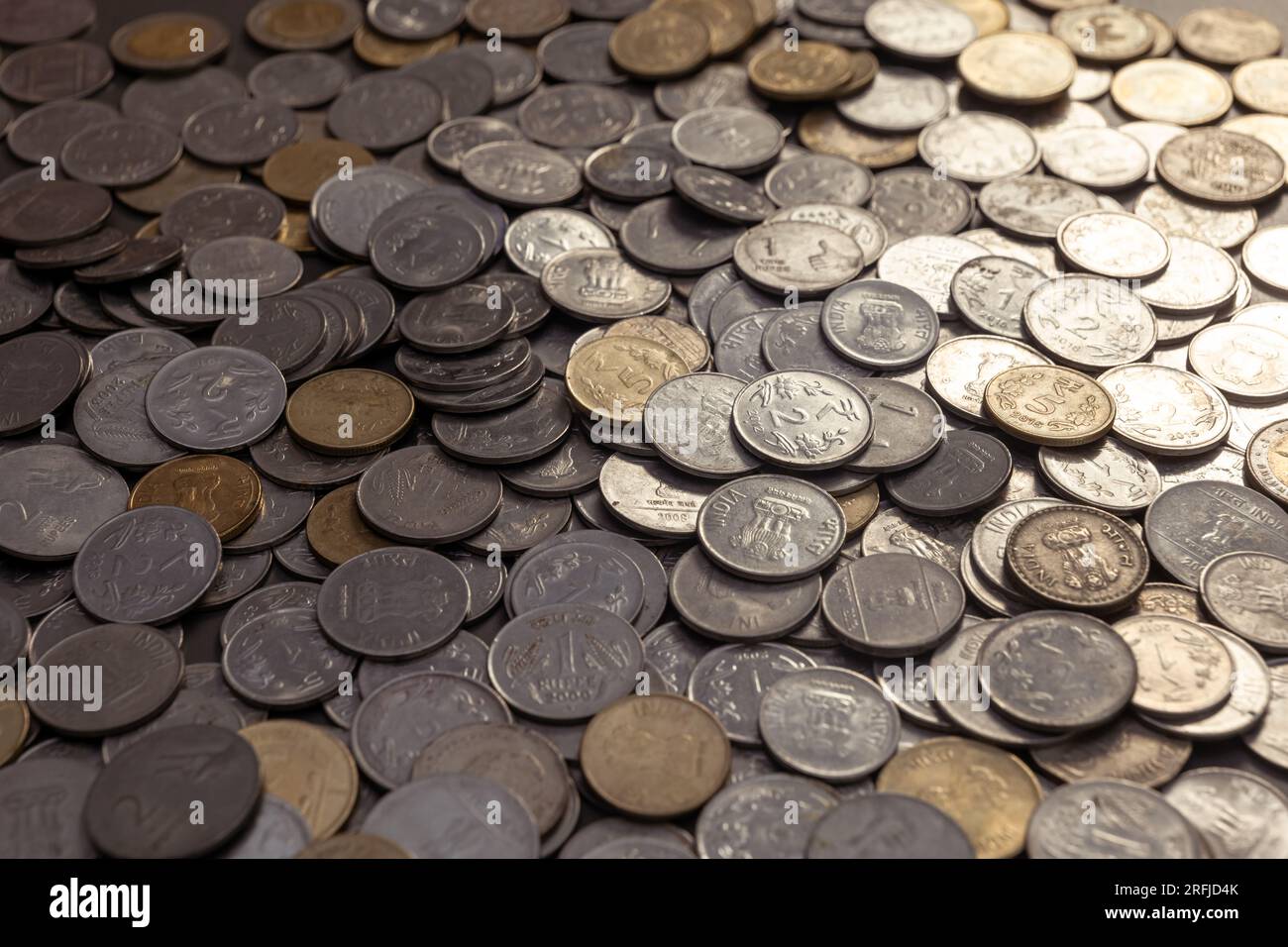 This stock image shows a pile of Indian rupees coins spread on a table ...