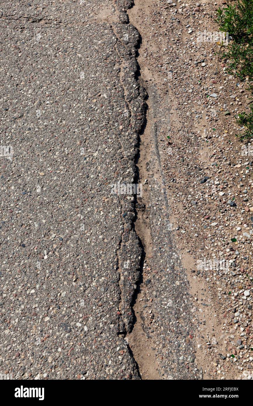an asphalt road with a lot of holes and damage, a poorly made ...