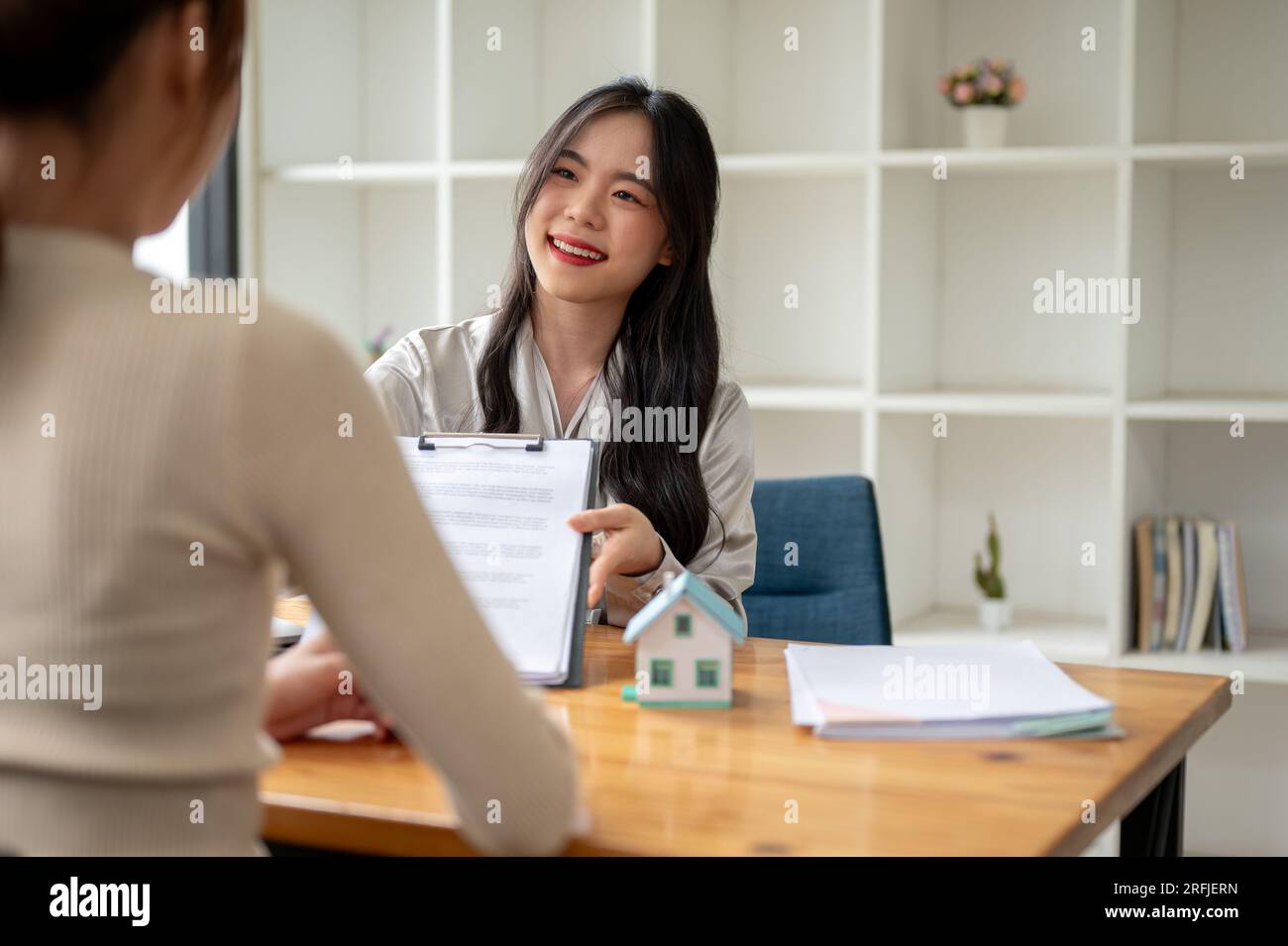 A beautiful and professional Asian female real estate agent or realtor ...