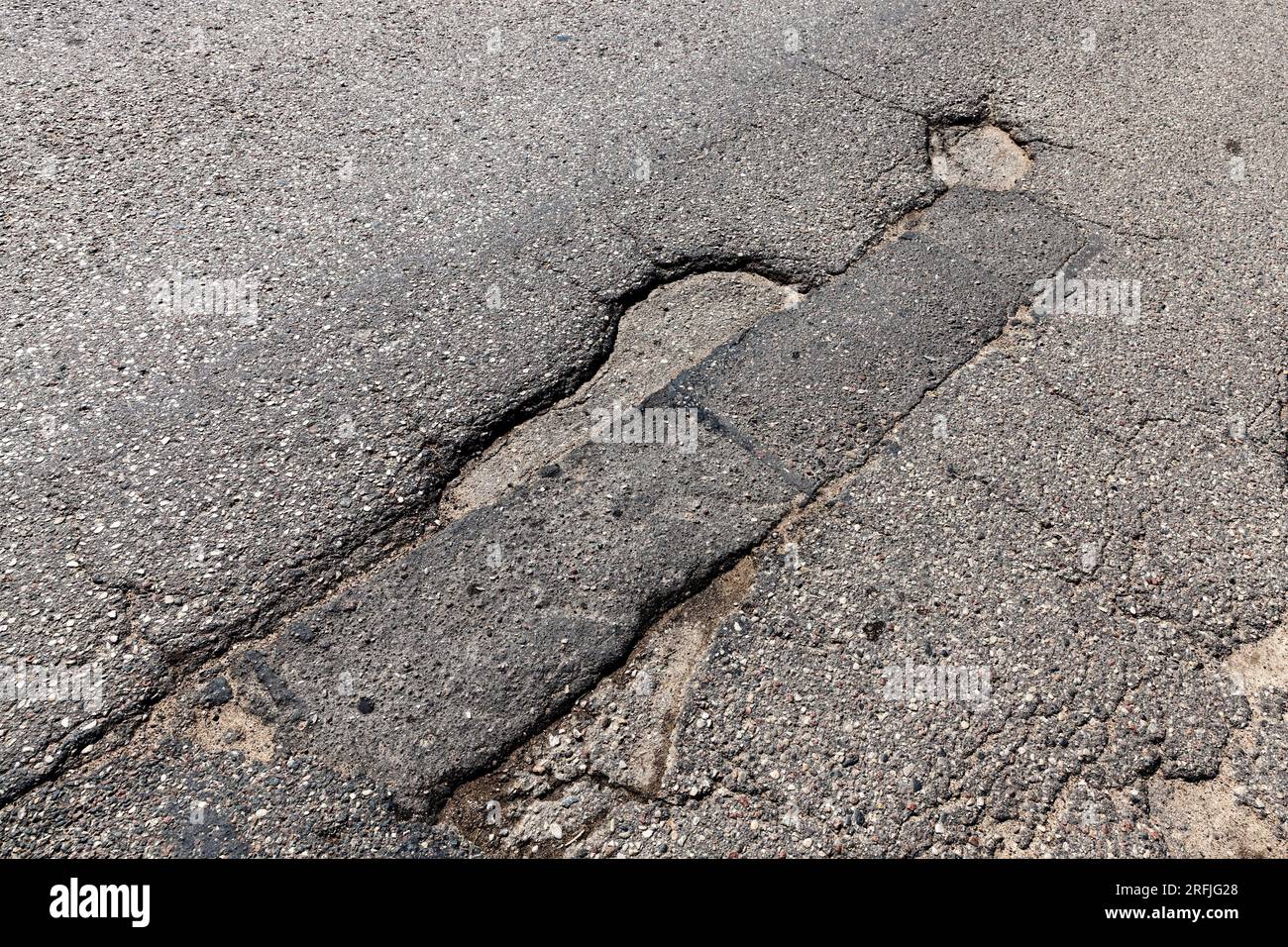 an asphalt road with a lot of holes and potholes, a poorly made asphalt ...