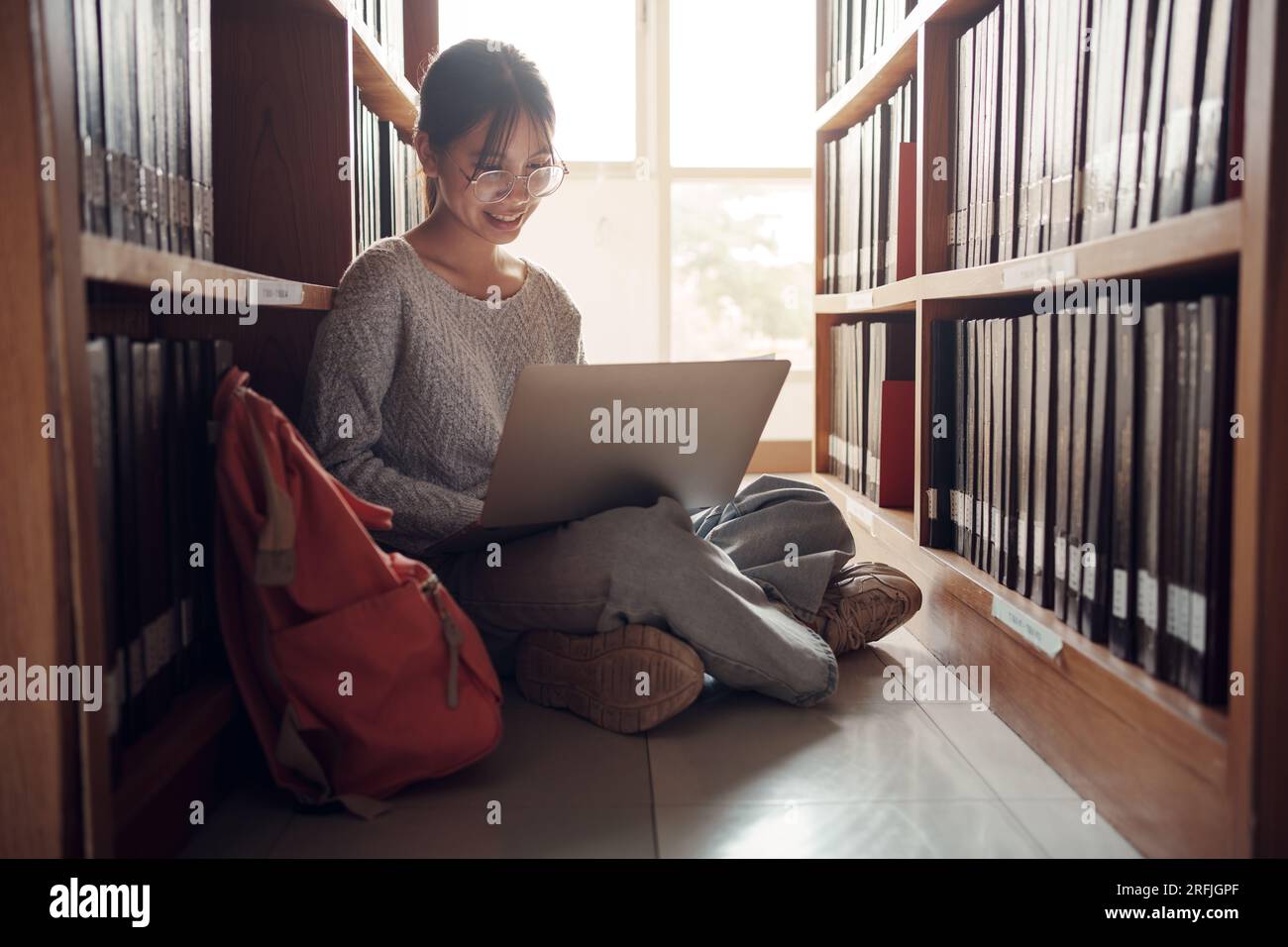 Student girl sitting on floor and using laptop, Writes notes for paper ...
