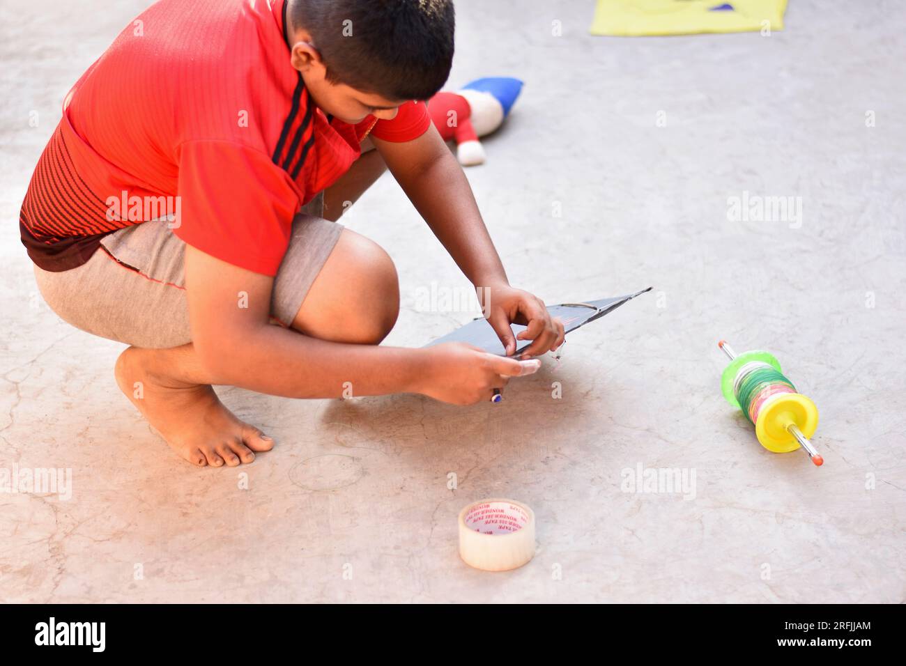 INDIA, MAHARASHTRA, PUNE, January 2023, A Boy fixing his broken kite ...