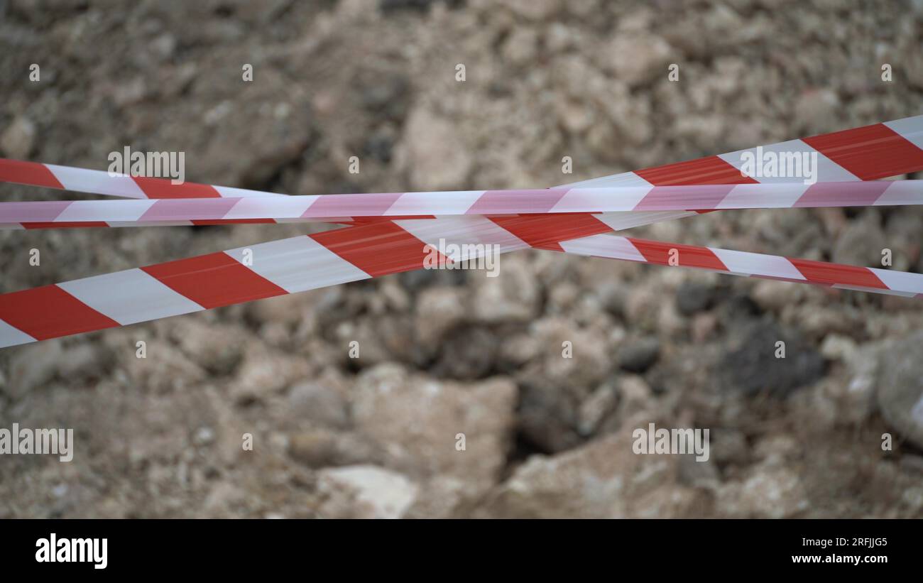 Red white barrier tape trenches. Focus on red and white barrier tape at ...