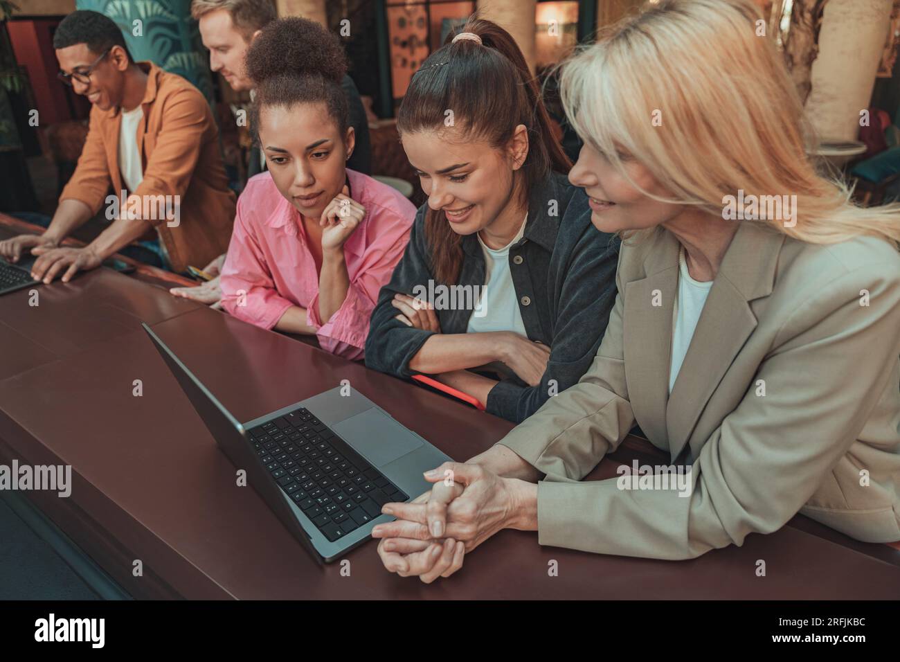 Friendly diverse business people laughing working on project together ...