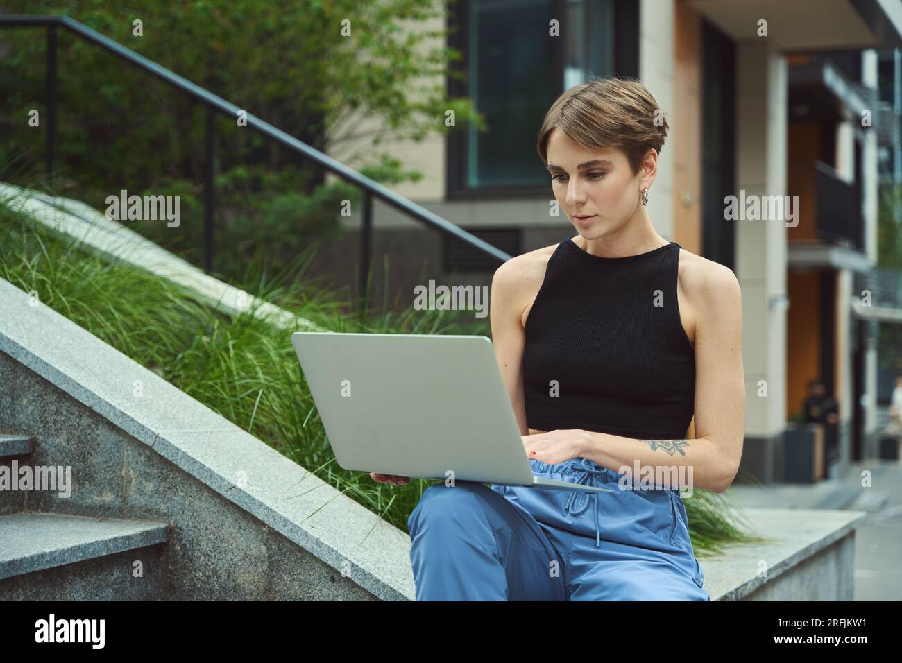 Female freelancer doing work tasks in urban environment Stock Photo - Alamy