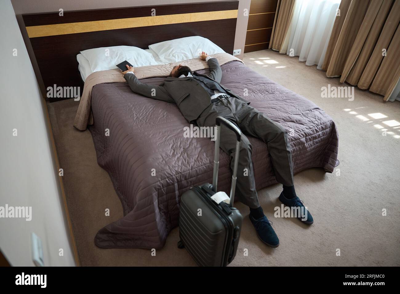 Tired traveler is resting from the road in the sleeping area of hotel ...