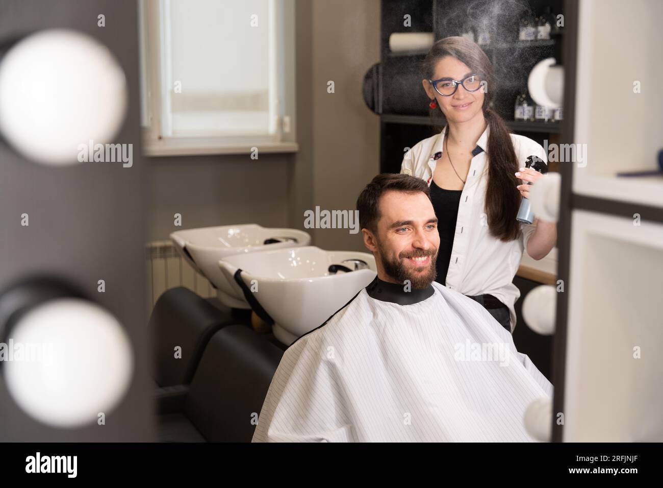 Cute barber woman in barbershop styling male hair Stock Photo - Alamy