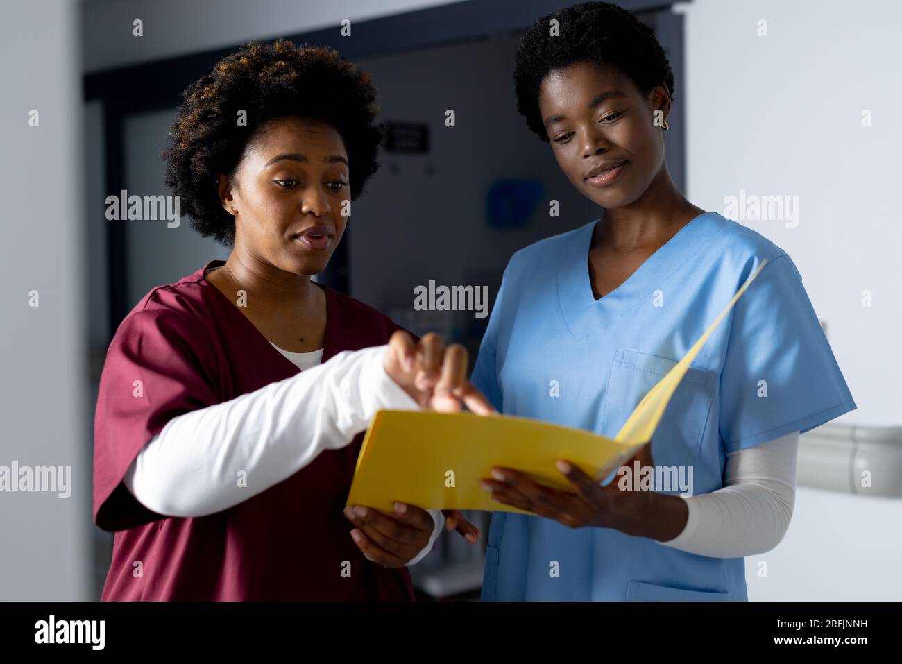 African american female doctors holding documents and discussing work ...