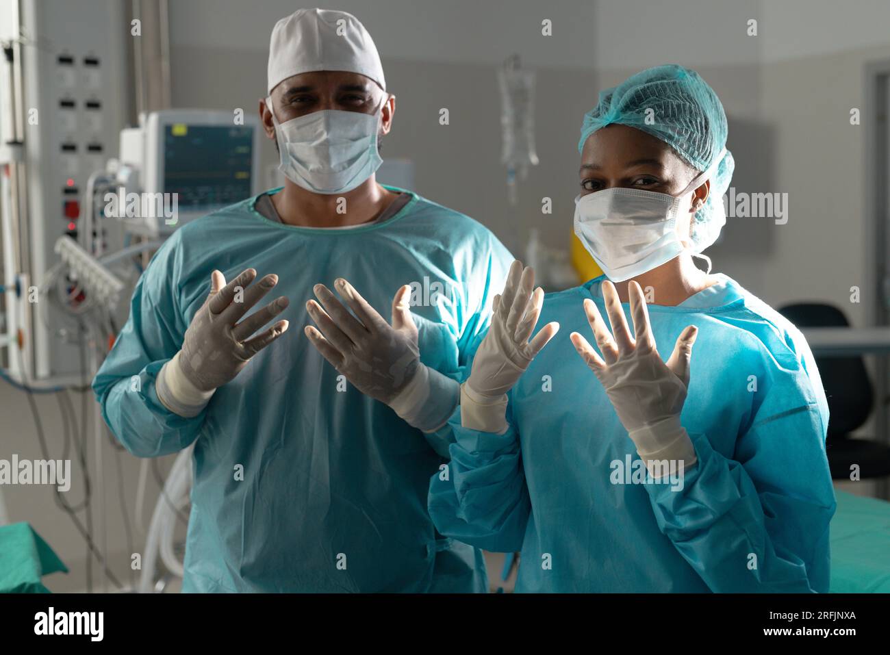 Portrait of diverse surgeons wearing surgical gowns in operating ...