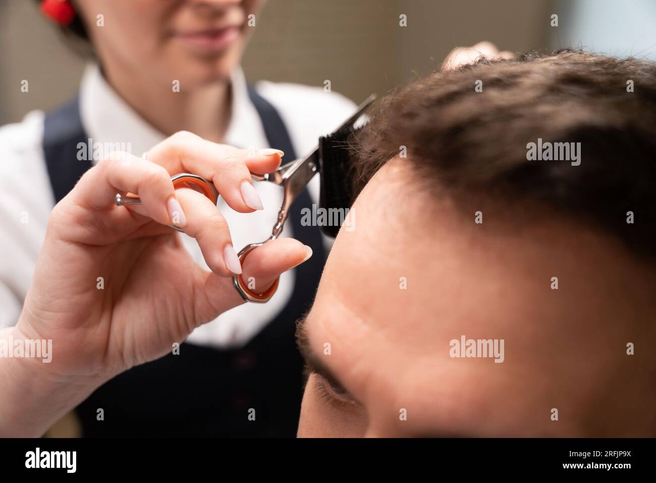 Master barber cuts a client under a comb with scissors Stock Photo - Alamy