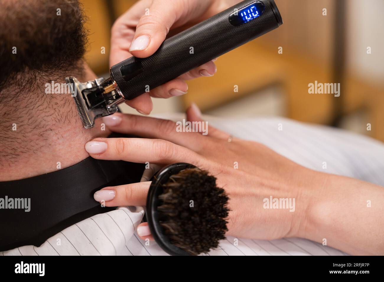 Female barber cuts a mans beard Stock Photo - Alamy