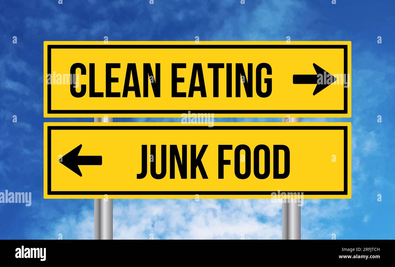 Clean eating or junk food road sign on blue sky background Stock Photo ...