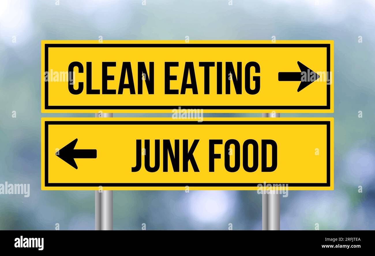 Clean eating or junk food road sign on blur background Stock Photo - Alamy